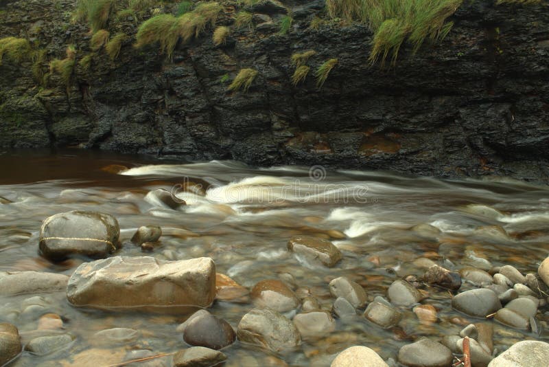 Shallow River with Lots of Stones beside a Cliff Stock Image - Image of ...