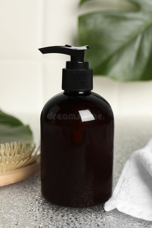 Shampoo Bottle, Hair Brush, Towel and Green Leaf on Light Table Stock ...