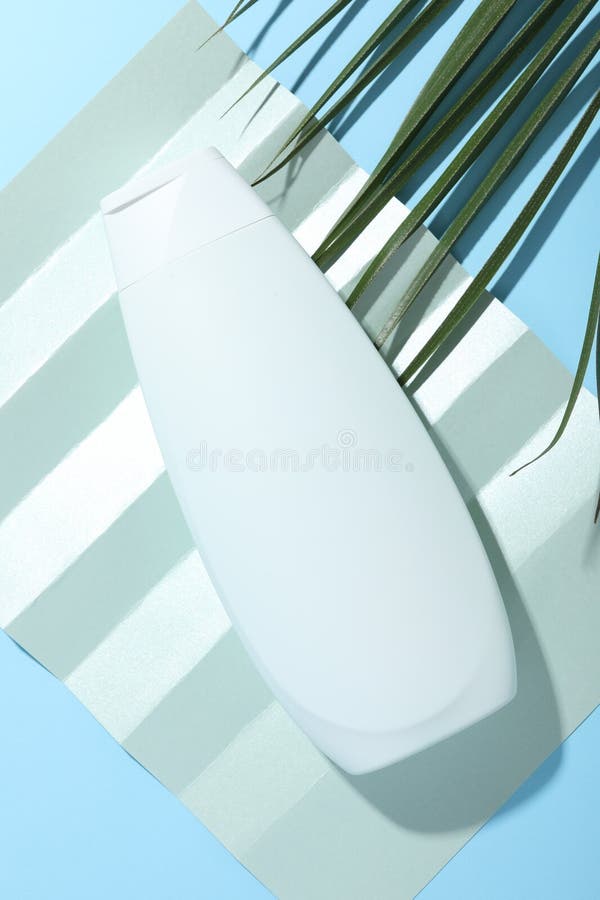 Shampoo in Bottle and Palm Leaf on Light Blue Background, Top View ...