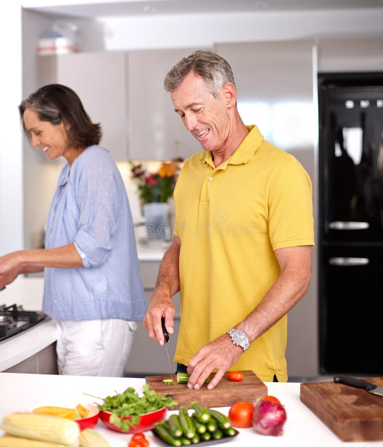 Sharing Responsibilities in the Kitchen. a Mature Couple Preparing a ...