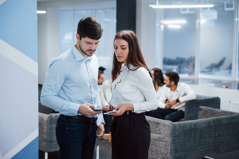 Sharing Some Information. Two Office Workers in Classic Clothes Talking ...