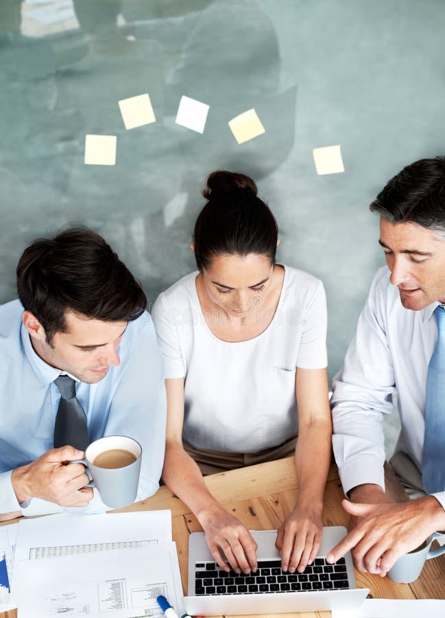 Sharing the Workload. Group of Businesspeople Working Together on a ... Sharing the Workload. Group of Businesspeople Working Together on a ...