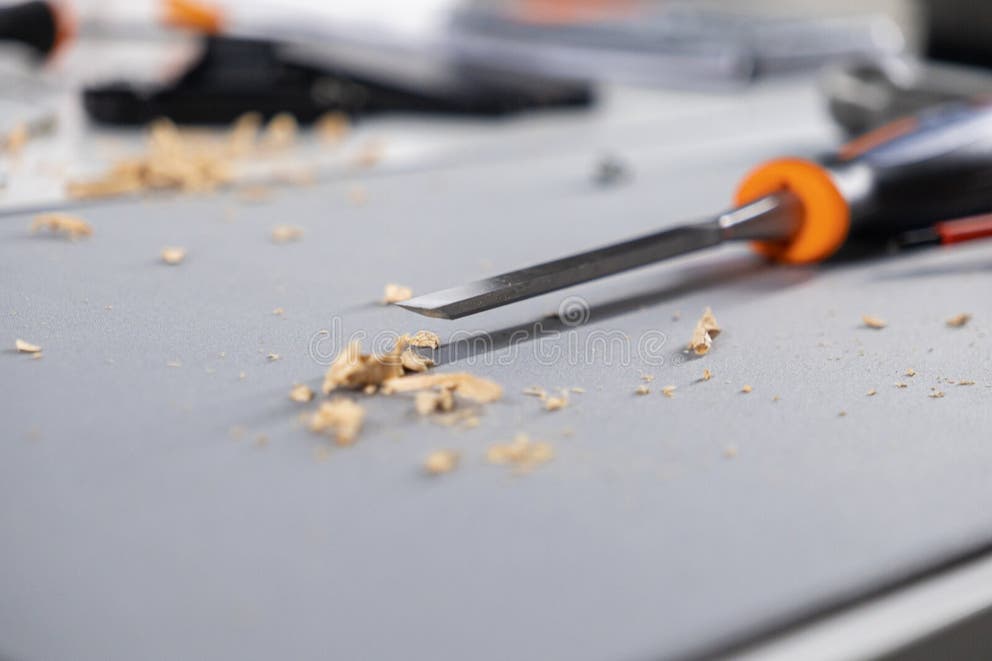 Sharp Chisel Lying on a Workbench with Scattered Wood Shavings, Close ...