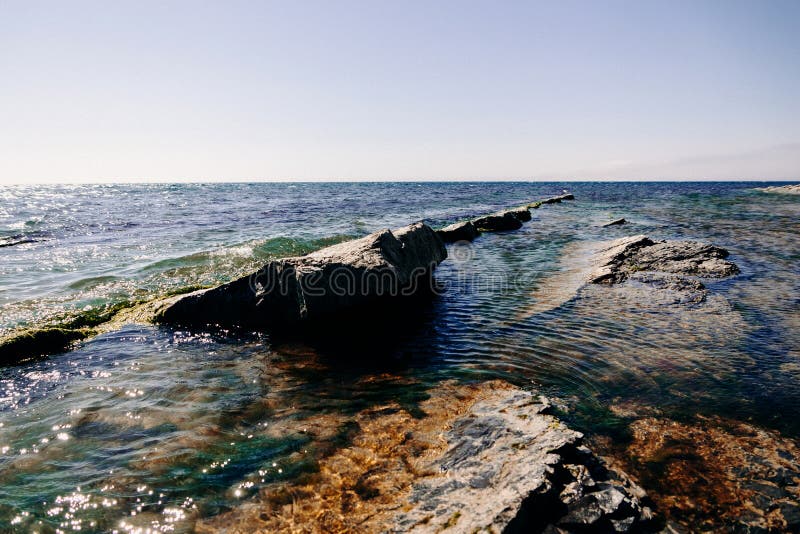 Sharp Coastal Cliffs Protruding from Sea Water Covered with Green and ...