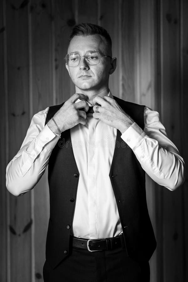 Sharp Elegance: a Black and White Portrait of a Man Adjusting His Tie ...