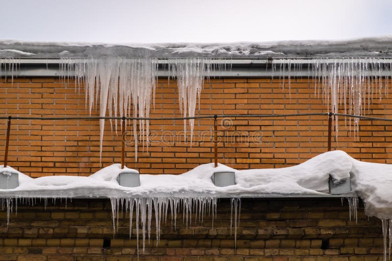 Sharp Icicles Hanging on the Edge of the Roof. Melting Snow Forms ...