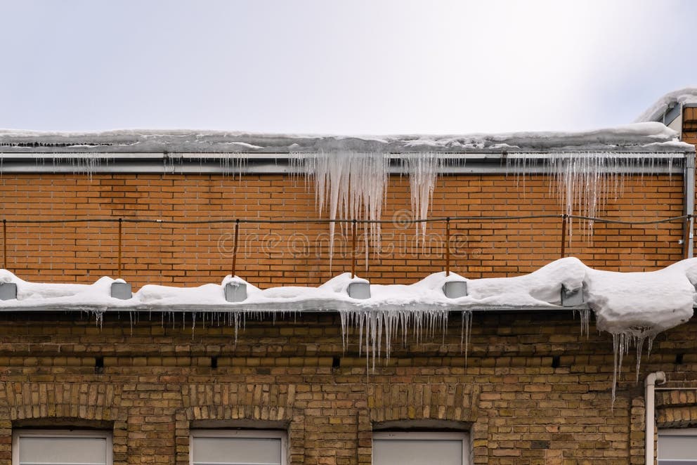 Sharp Icicles Hanging on the Edge of the Roof. Melting Snow Forms ...
