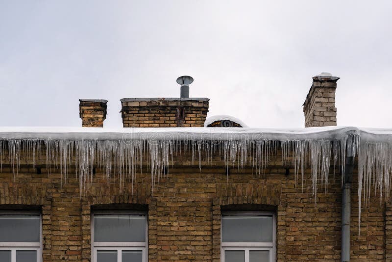 Sharp Icicles Hanging on the Edge of the Roof. Melting Snow Forms ...