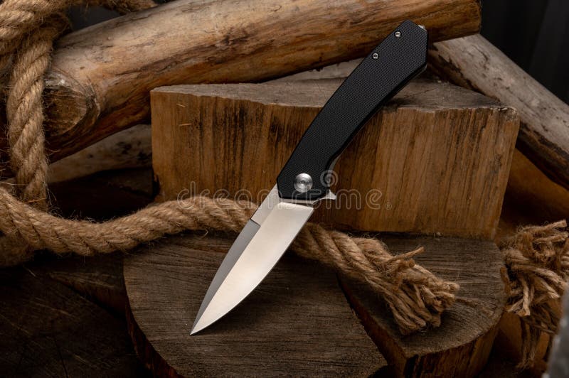 A Sharp Knife with a Black Handle on a Stump with a Rope Stock Image ...