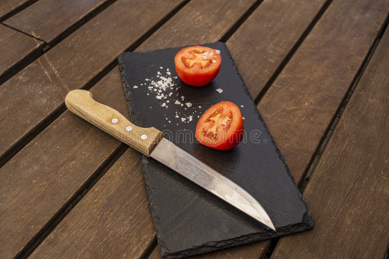 A Sharp Knife on a Black Slate Surface after Halving a Tomato Stock ... A Sharp Knife on a Black Slate Surface after Halving a Tomato Stock ...