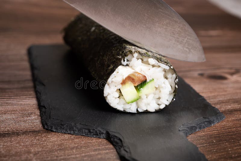 A Sharp Knife Cuts a Rolled-up Sushi Roller Stock Image - Image of ...