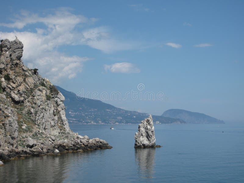 A Sharp Rock on the Beach Against a Blue Sky Stock Photo - Image of ...