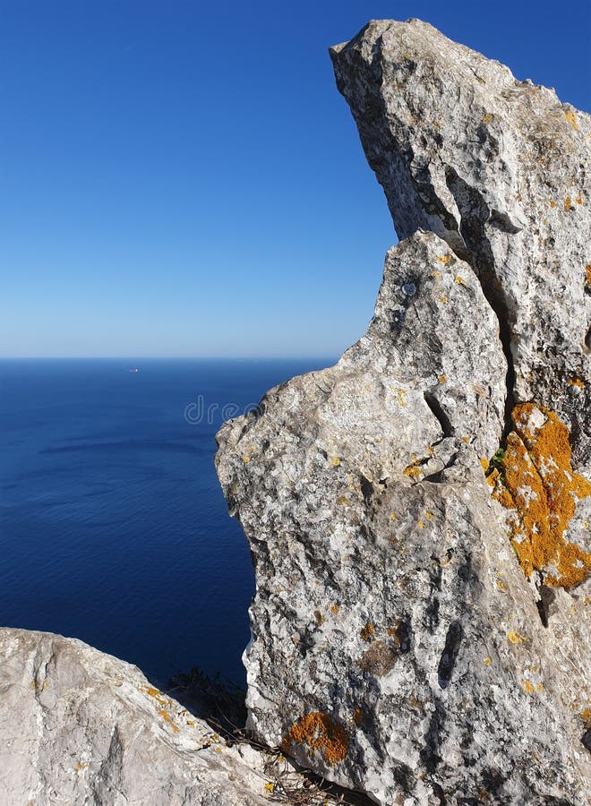 A Sharp Rock before the Blurry Deep Blue Sea Stock Photo - Image of ...