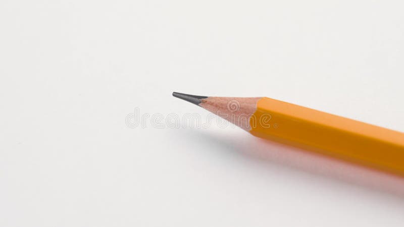 A Sharpened Graphite Yellow Pencil is Placed on a White Paper Blank ...