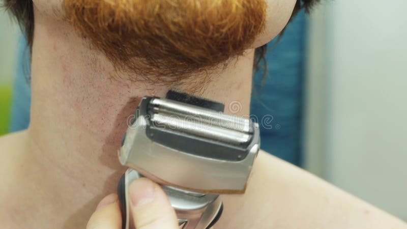 Shaving Process of a Young Man with a Red Beard, Electric Razor, Close ...