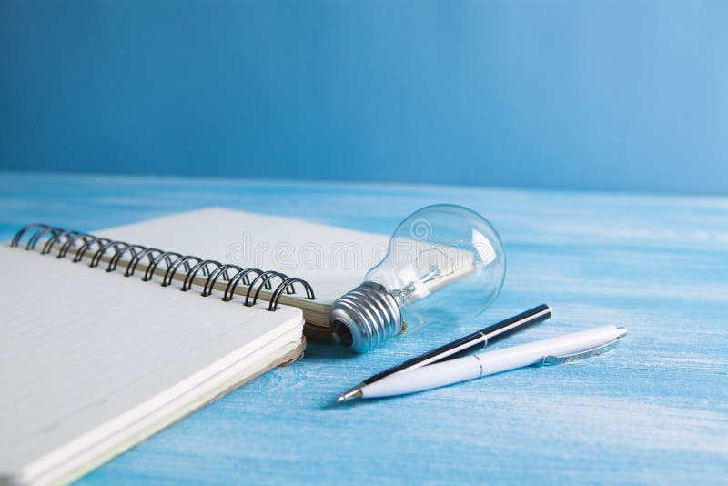Sheet with a Notebook with Pens and a Light Bulb on the Table Lk. New ...