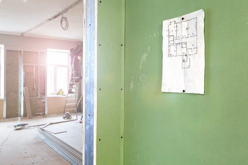 Sheet of Project on the Wall and Construction Worker Install ...