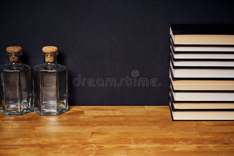 Shelf with Bottles and Books on a Black Wall Stock Image - Image of ...