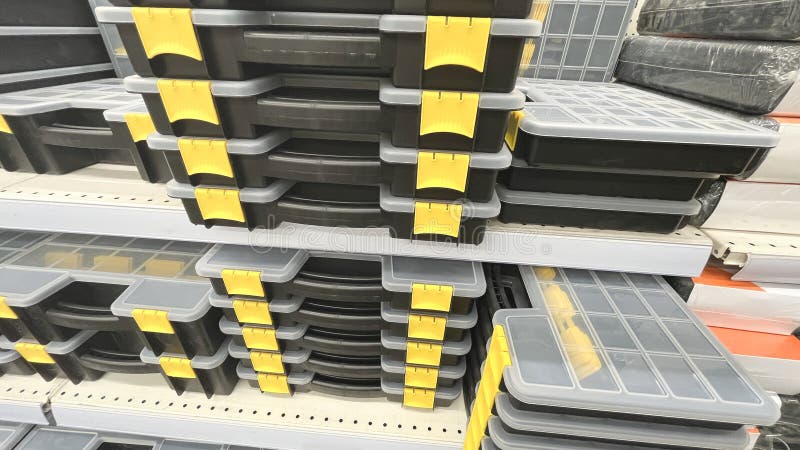 A Shelf of Plastic Containers with Yellow Handles. the Containers are ...