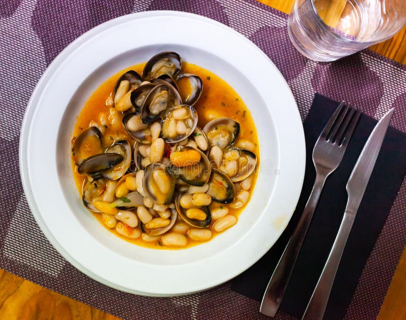 Shellfish in a Plate with White Beans on Table in Restaurant Stock ...