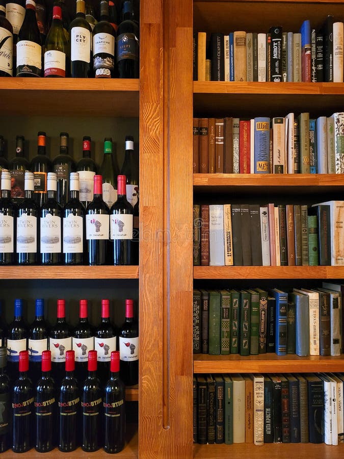 Shelves with Books and Wine Bottle Indoors. Interior Design Editorial ...