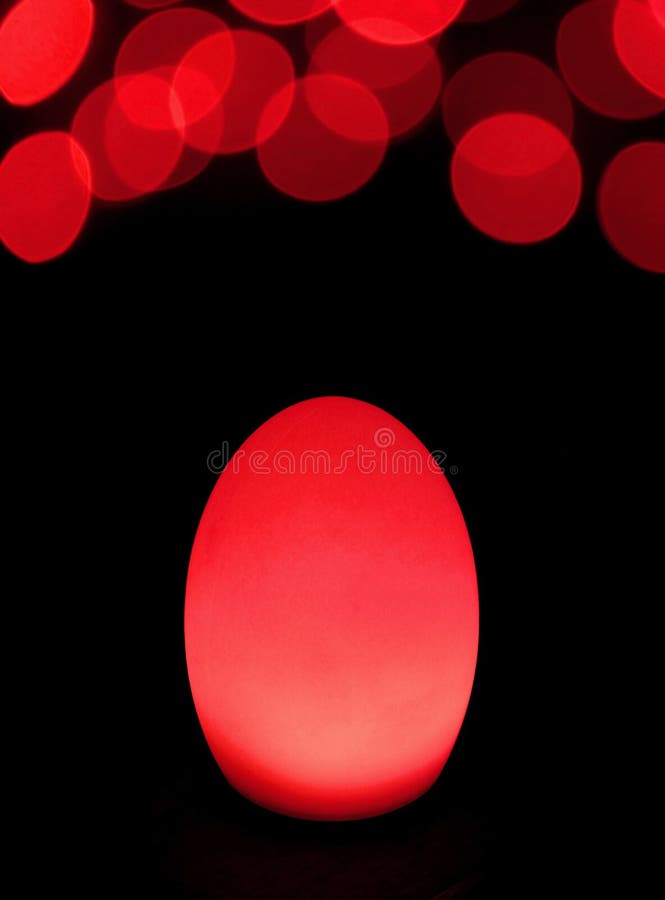 Shining Red Egg Shaped Table Lamp with Bokeh Light on Dark Background ...