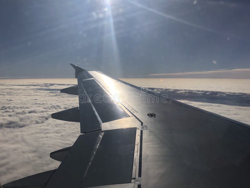 Shiny Airplane Wing Over Clouds Stock Image - Image of sunlight, scenic ...