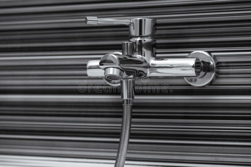 Shiny Bath Water Tap Installed on Black and White Wall Stock Image ...