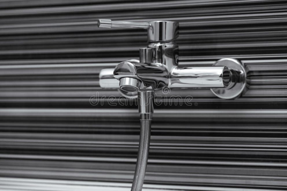 Shiny Bath Water Tap Installed on Black and White Wall Stock Image ...