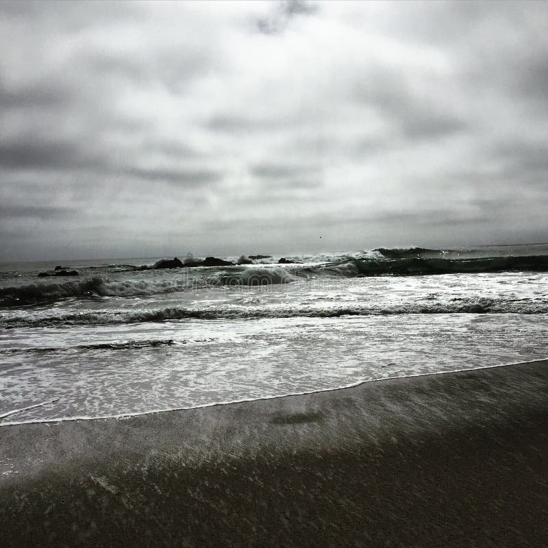 Shiny Beach Side Rocks Under a Layer of Clouds. Stock Photo - Image of ...