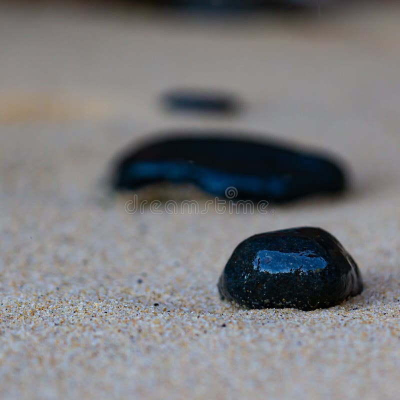 Shiny Black Pebbles on Sand Stock Image - Image of sand, shiny: 193299887