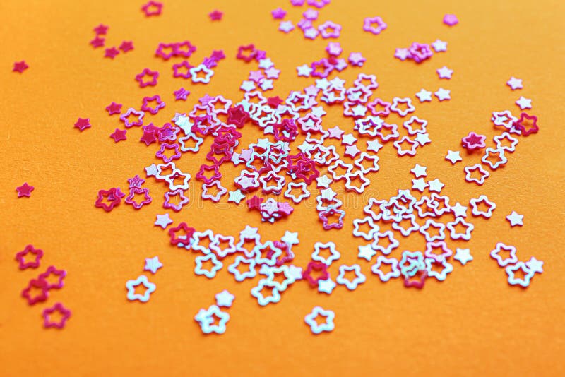 Shiny Bright Star Shaped Glitter on Pale Orange Background Stock Photo ...