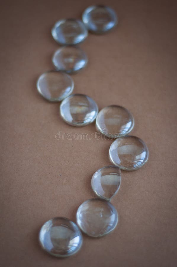 Clear Marbles with Light Reflections on a Brown Background. Stock Photo ...