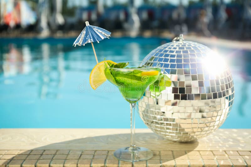 Shiny Disco Ball and Refreshing Cocktail on Edge of Swimming Pool ...