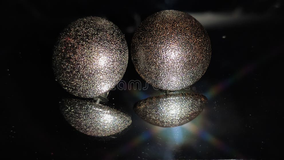 Shiny Ear Rings on a Reflective Surface Stock Image - Image of black ...