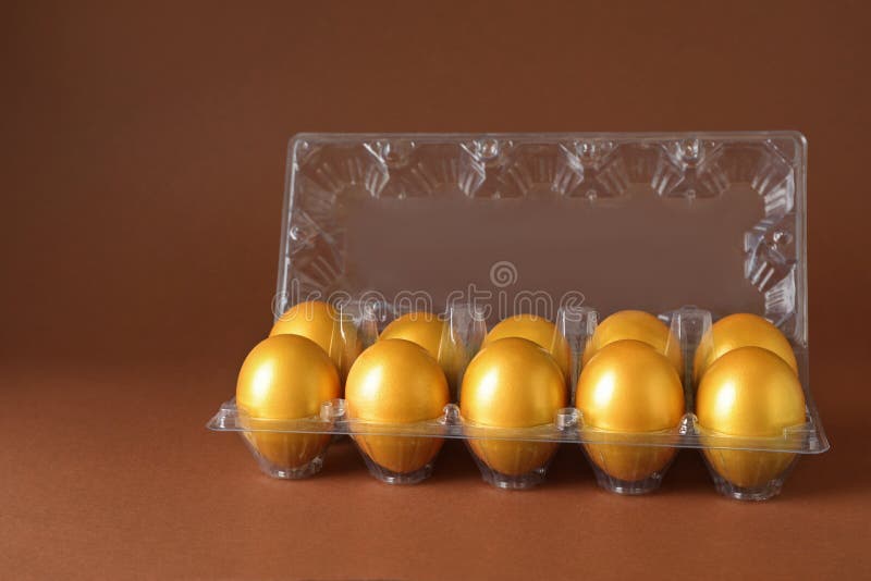 Shiny Golden Eggs in Plastic Box on Brown Background Stock Image ...