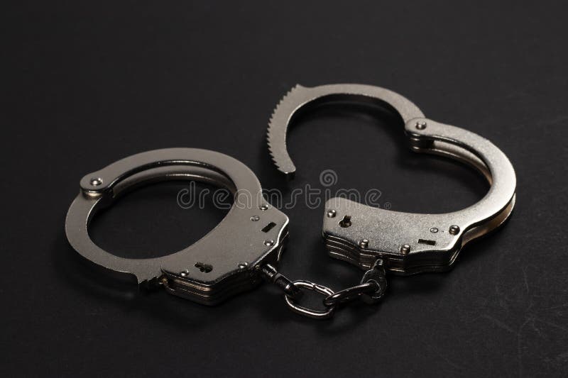 Shiny Metal Handcuffs on the Dark Table Stock Photo - Image of symbol ...