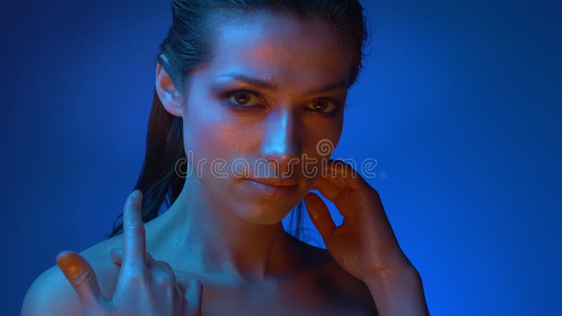 Shiny Model with Glitter Makeup Standing in Blue Neon Lights Touches ...