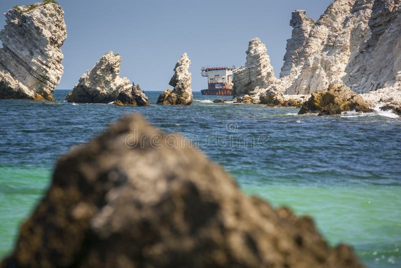 Ship Wreck Behind the Sharp Rocks in Sea Under Sky Stock Photo - Image ...