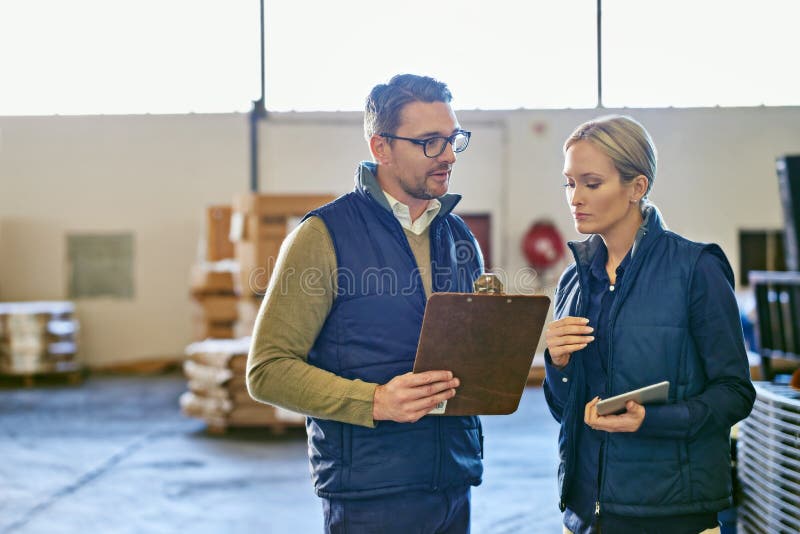 These Shipments are a Priority. Shot of Two People Looking at Paperwork ...