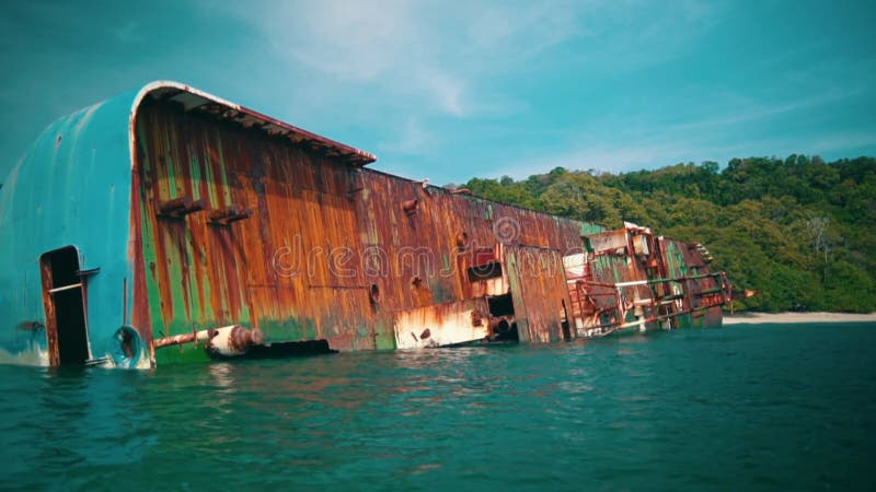 A Shipwreck Stranded in Front of an Island Full of Green Trees and Blue ...