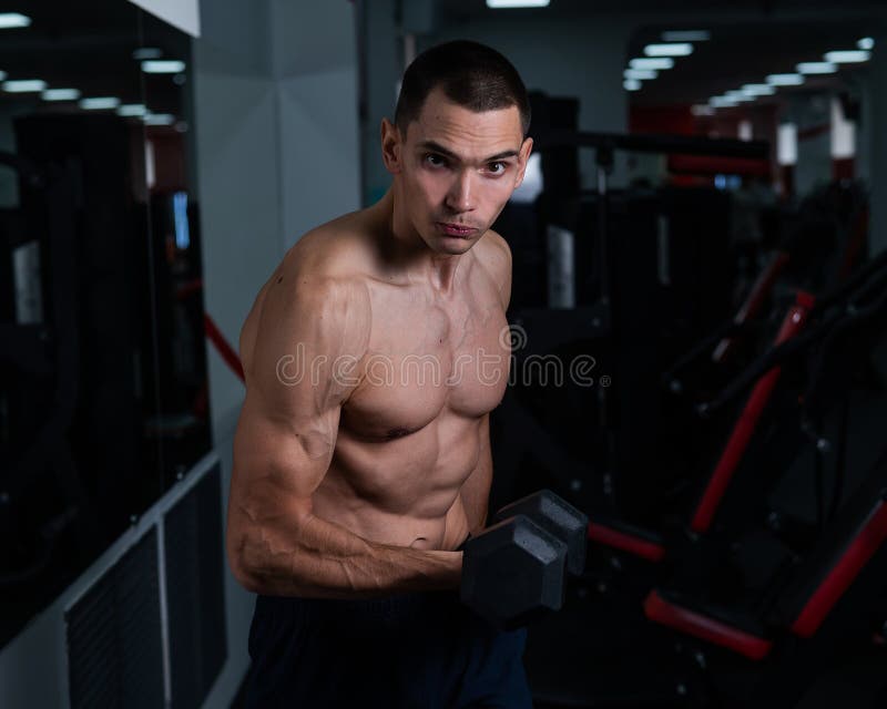 Shirtless Man Doing Bicep Exercises with Dumbbells in the Gym. Stock ...