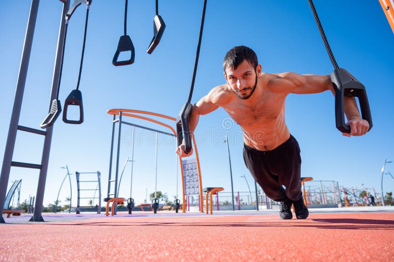 Shirtless Man Doing Loop Exercises Outdoors. Stock Image - Image of ...