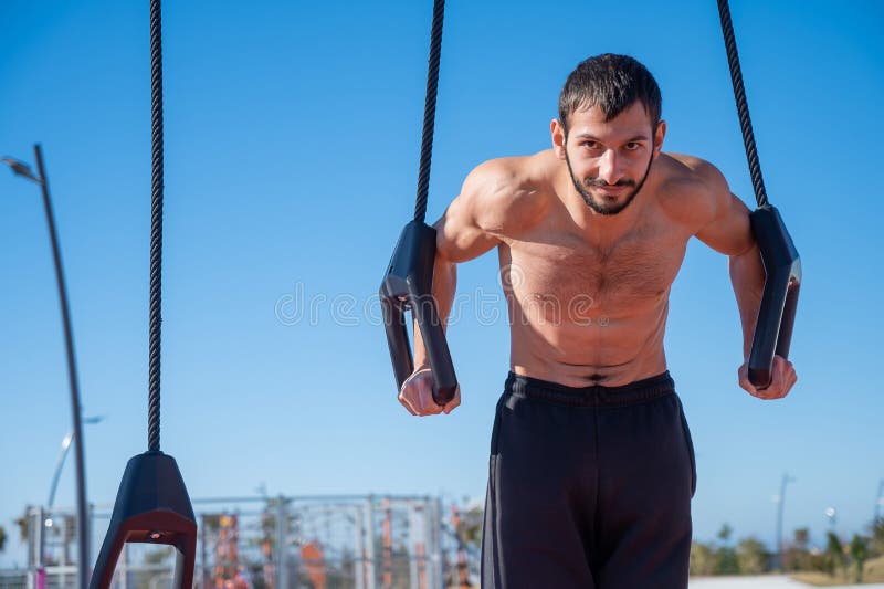 Shirtless Man Doing Loop Exercises Outdoors. Stock Image - Image of ...