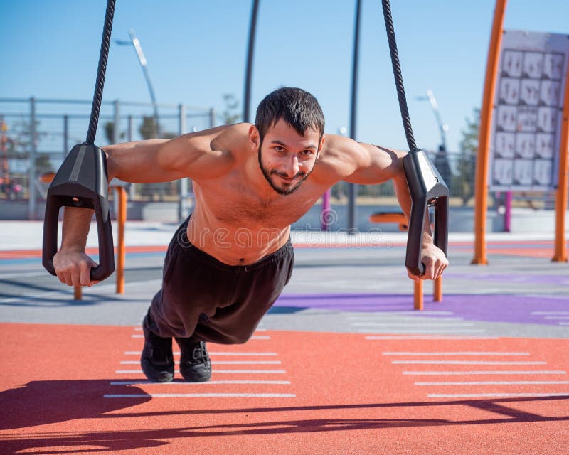 Shirtless Man Doing Loop Exercises Outdoors. Stock Image - Image of ...