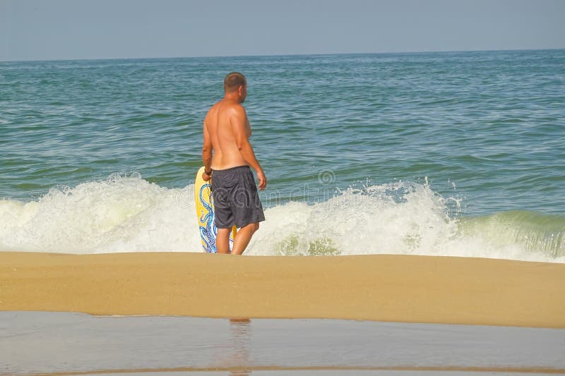 Shirtless Man Walking on a Sandy Beach, Getting Ready To Surf in the ...