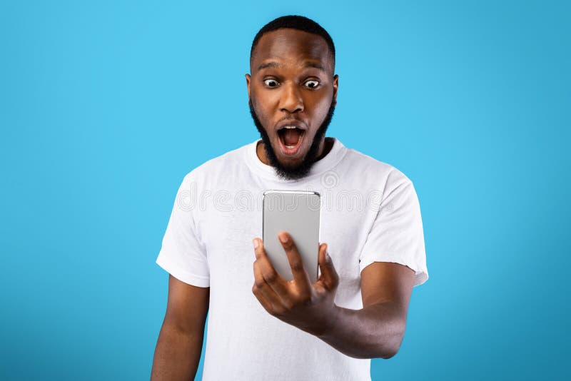 Shocked Black Guy Holding Phone Reading Message Over Blue Background