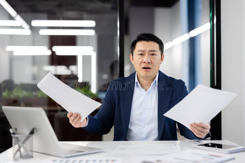 Shocked Chinese Office Worker Sitting at Personal Workplace with ...