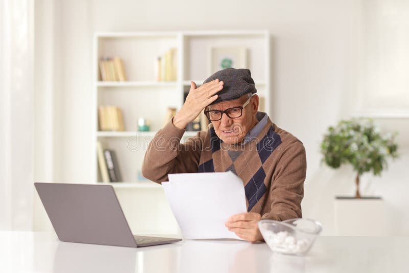 Shocked Elderly Man Reading a Document in Front of a Laptop Computer ...
