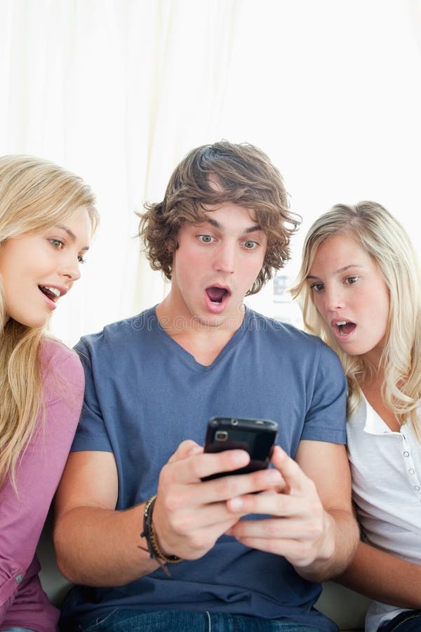 Shocked Friends Look at the Man S Phone Stock Photo - Image of looking ...